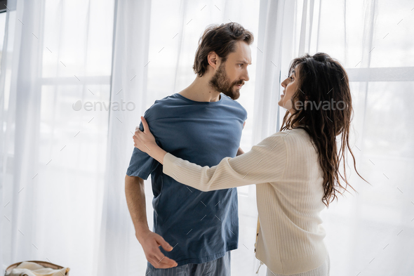 Scared woman touching and talking to angry boyfriend during conflict at ...