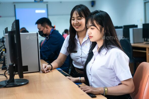 East Asian females in a professional office setting using a computer ...