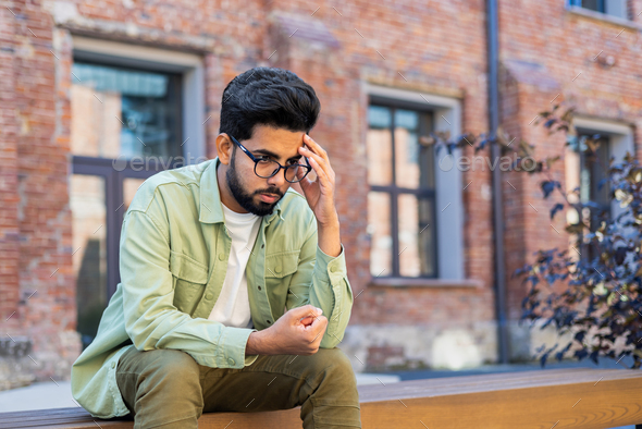 Sad depressed man sitting on bench outside office building, businessman ...