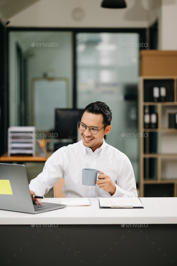 Confident Asian man with a smile standing holding notepad and tablet at ...