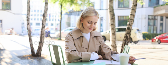 Portrait of thoughtful young woman, writing in her documents, making ...