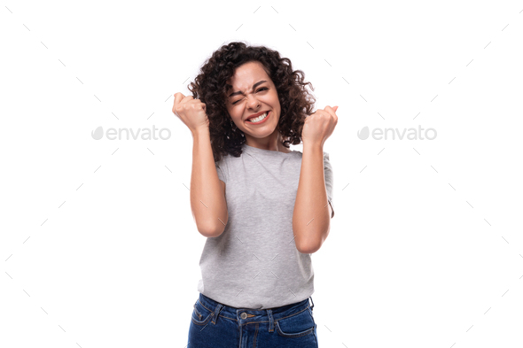 kind slender young caucasian woman with careless black curly hair is ...