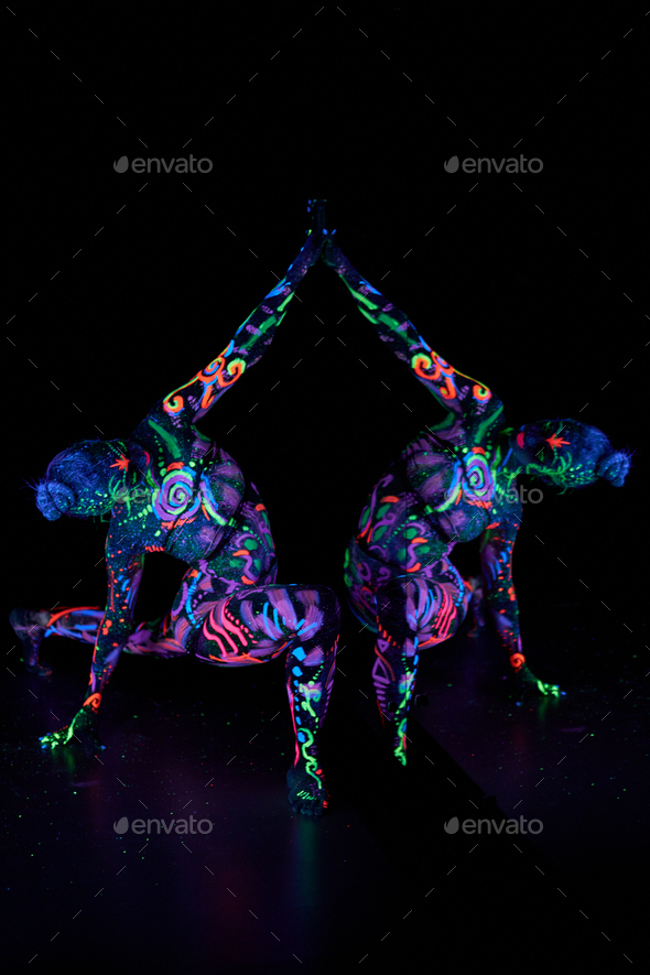 Art woman body art on the body dancing in ultraviolet light. Bright ...