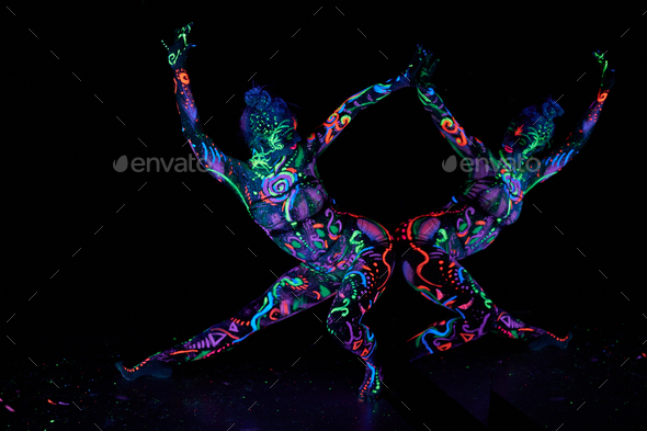 Art woman body art on the body dancing in ultraviolet light. Bright ...