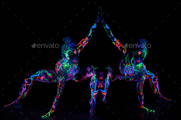 Art woman body art on the body dancing in ultraviolet light. Bright ...