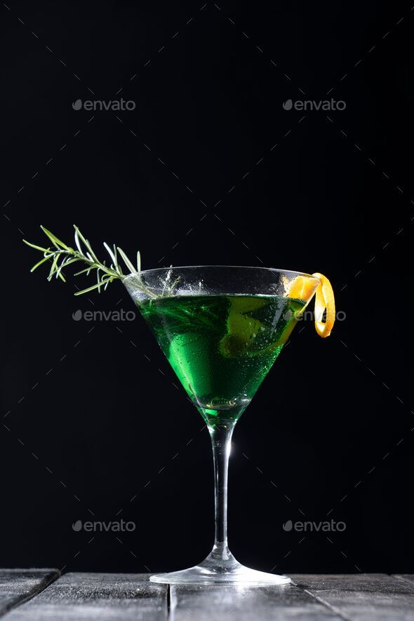 Refreshing green martini cocktail in a martini glass on the black ...