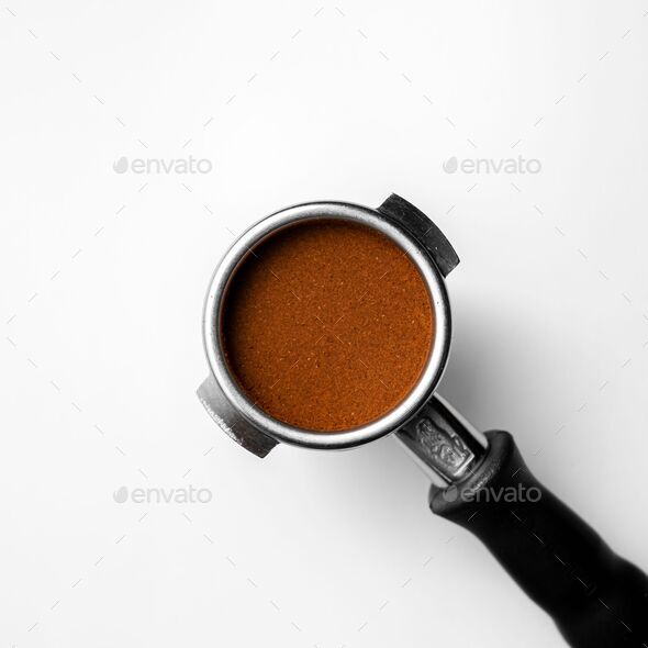 Closeup of a portafilter full of coffee isolated on white background ...
