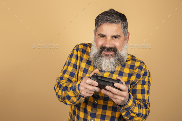 Handsome gamer with a beard playing video game using joystick with an ...