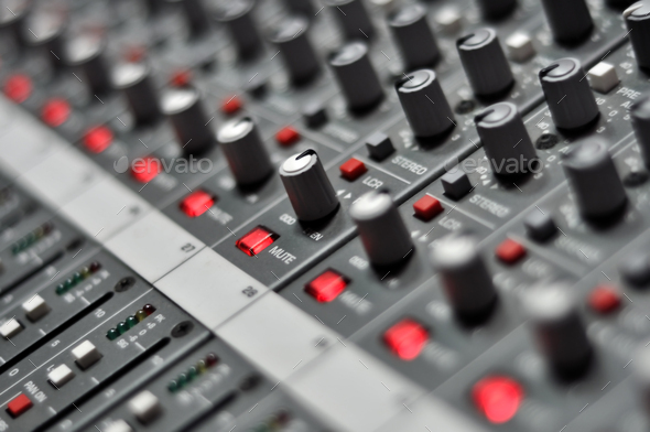 Close-up shot of buttons, levels, switches on an audio mixer control ...