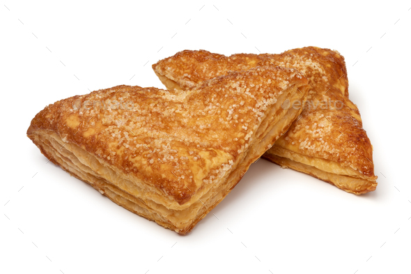 Pair of baked puff apple triangles pastry as a snack close up on white ...