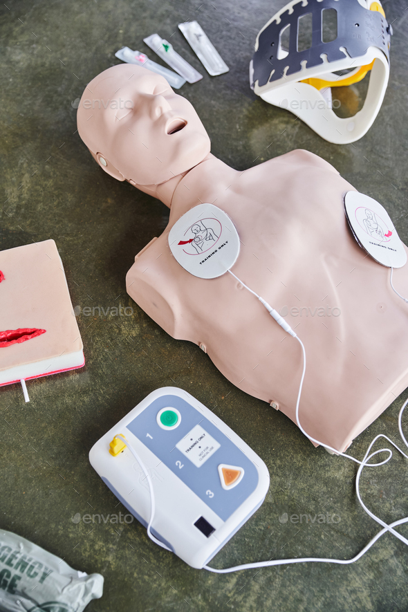 high angle view of CPR manikin, external defibrillator, wound care ...