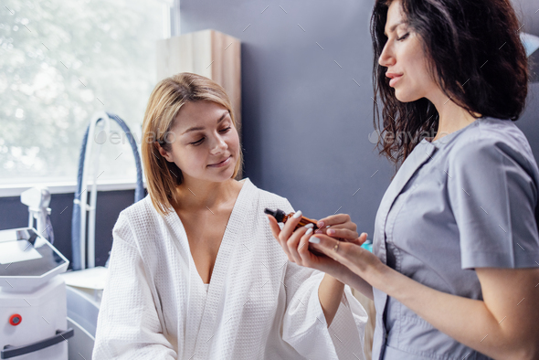 Pretty caucasian beautician communicates with her female client. Stock ...