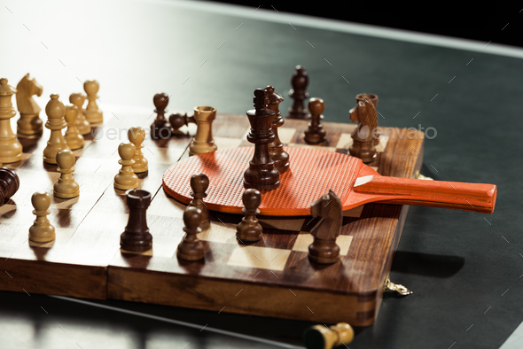 close up view of tennis racket and chess board with figures on tennis ...