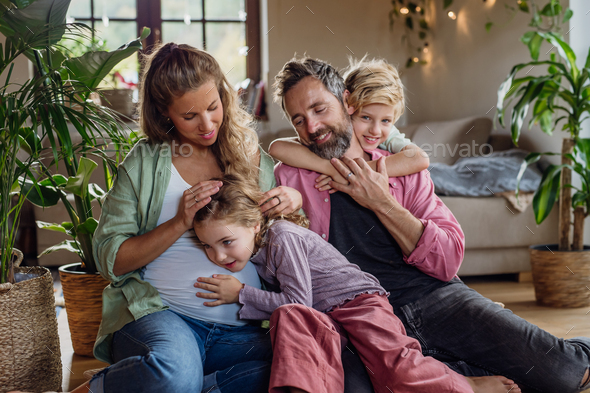 Portrait of young family at home. Pregnant mother with her children and ...