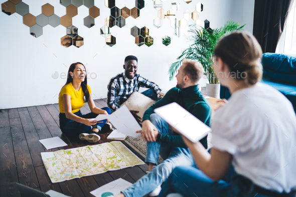 Cheerful diverse team members discussing project in workspace Stock ...