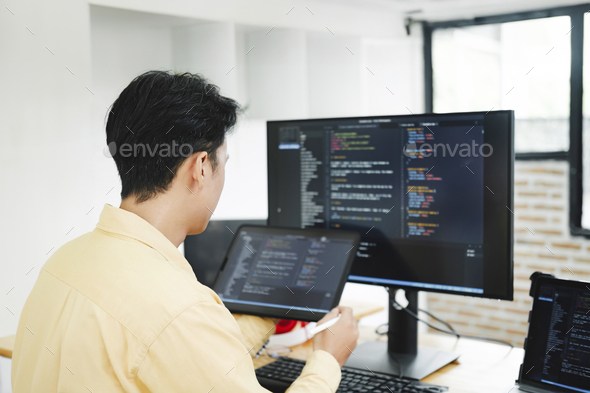 IT Programmer Starts Working on Desktop Computer. Stock Photo by ijeab