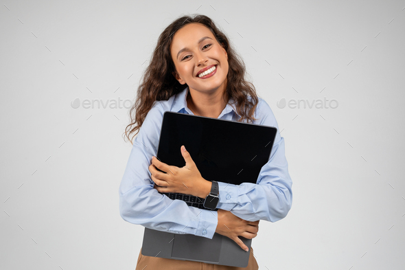 Cheerful pretty european millennial businesswoman hugs computer with ...