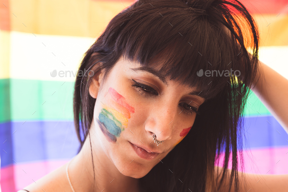 Brunette woman with LGBT symbol on face straightening hair Stock Photo ...