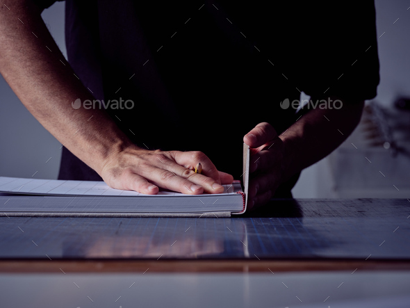 Faceless man making book cover while working at workshop Stock Photo by ...