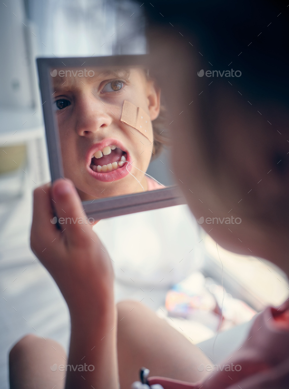 Fearless boy pulling out tooth with mirror Stock Photo by ADDICTIVE_STOCK