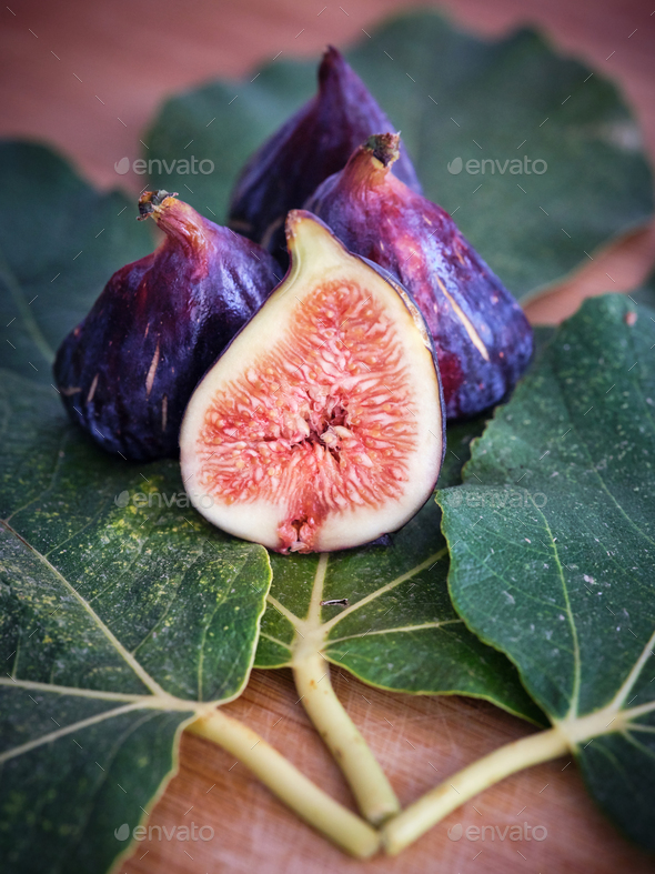 Halved and whole figs on sycamine leaves Stock Photo by ADDICTIVE_STOCK