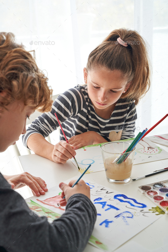 Children painting together at table Stock Photo by ADDICTIVE_STOCK
