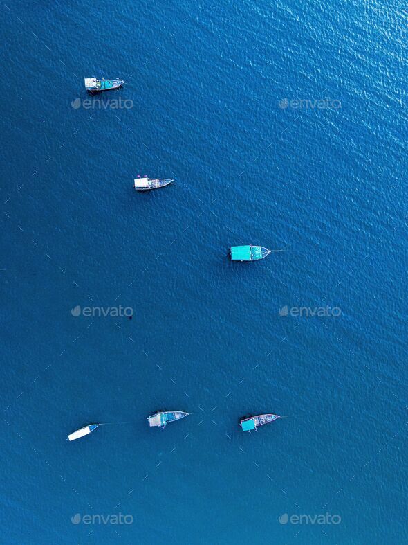 Vertical top view of boats in pure blue water Stock Photo by wirestock