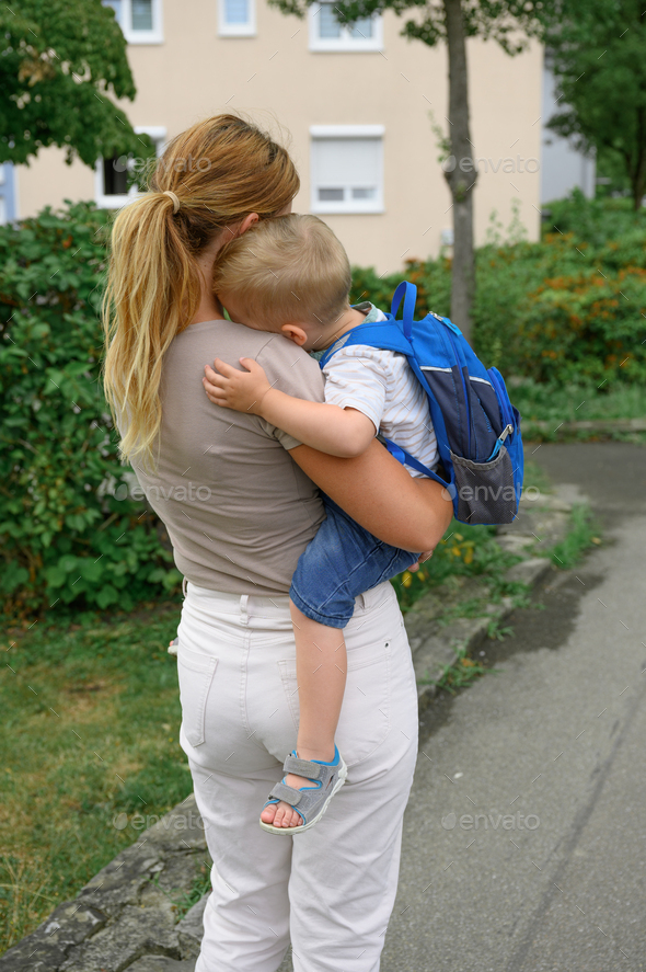 Unrecognizable mother standing and carrying anonymous kid in hands ...