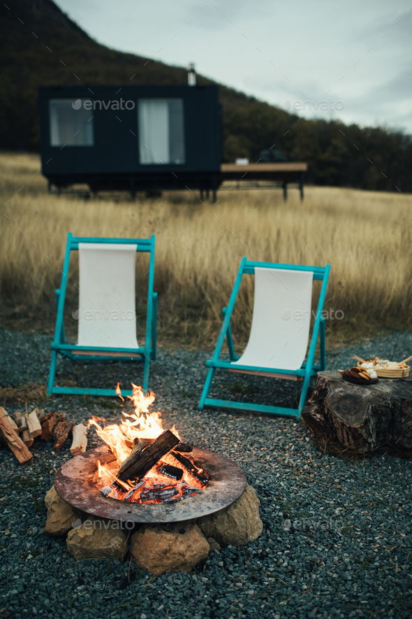 Campfire in the backyard with wooden house on the background. Stock ...