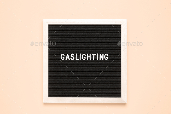 The word gaslighting on black letter board over isolated beige ...