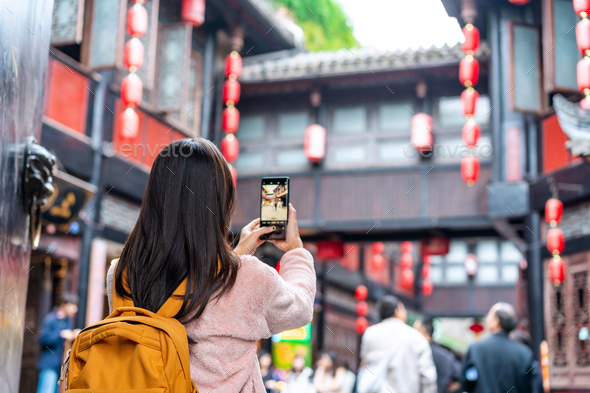 Young female tourist taking a photo of the Jinli Ancient Street in ...