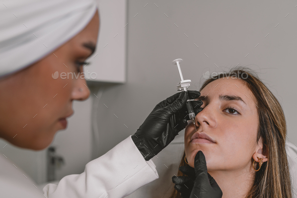 Doctor injecting botox in the lips of a young patient Stock Photo by ...