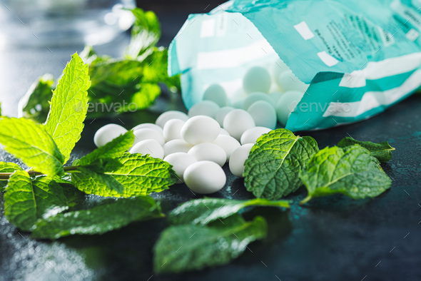 Mint candies. Menthol bonbons and mint leaves on black table. Stock ...