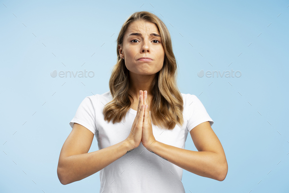 Portrait of upset woman asking, wishing for something, looking at ...