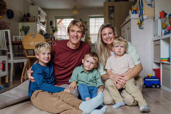 Portrait of family at home sitting on the floor. Beautiful mother with ...