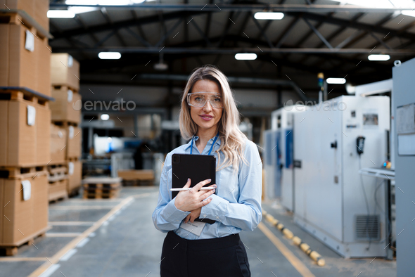 Female manager standing in modern industrial factory. Manufacturing ...