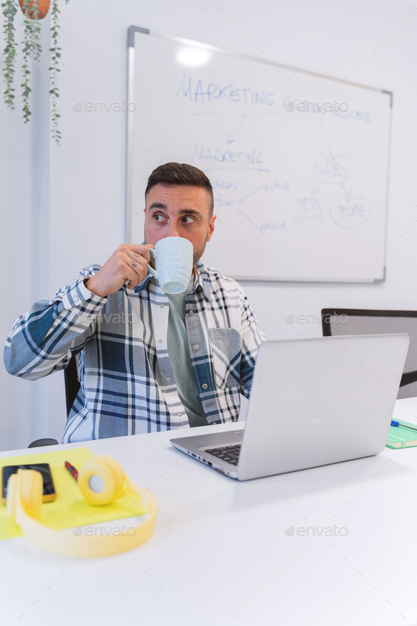 Man drinking coffee while working in the office. Stock Photo by ...