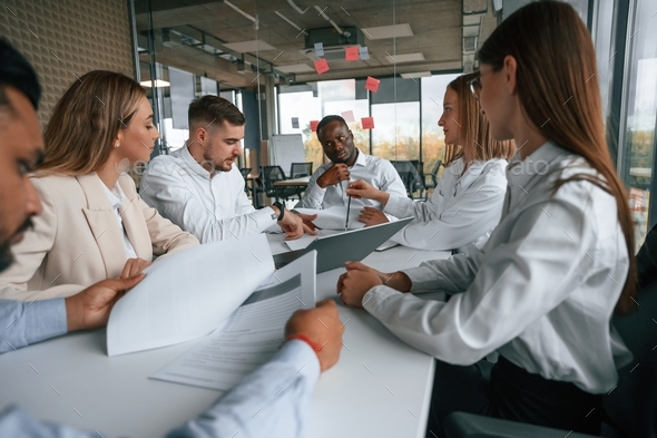 Brainstorming, holding documents, thinking. Group of office workers are ...