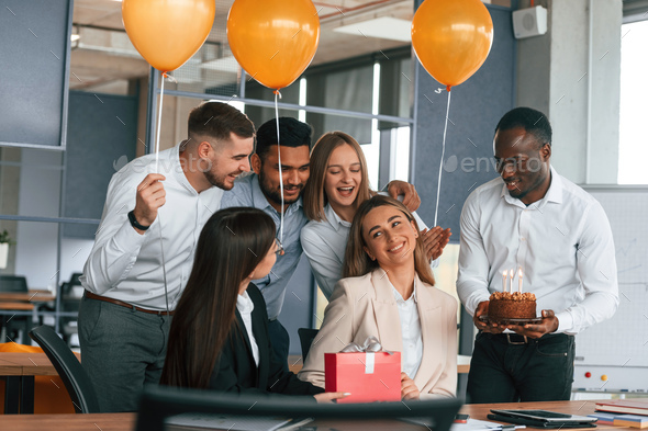 balloons and gift box. Employee having a birthday in the office, group ...