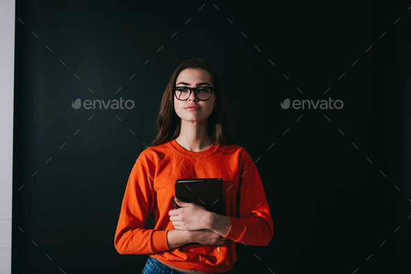 Pleasant woman hugging book on dark background Stock Photo by GaudiLab
