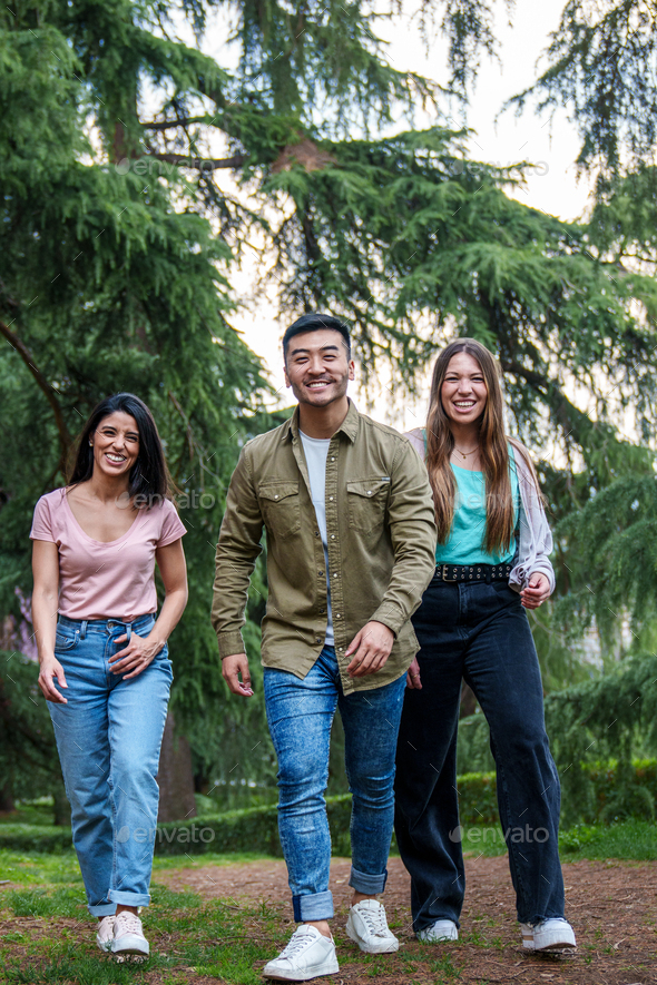 Three Friends Enjoying a Relaxed Walk in a Lush Park, Smiling Stock ...