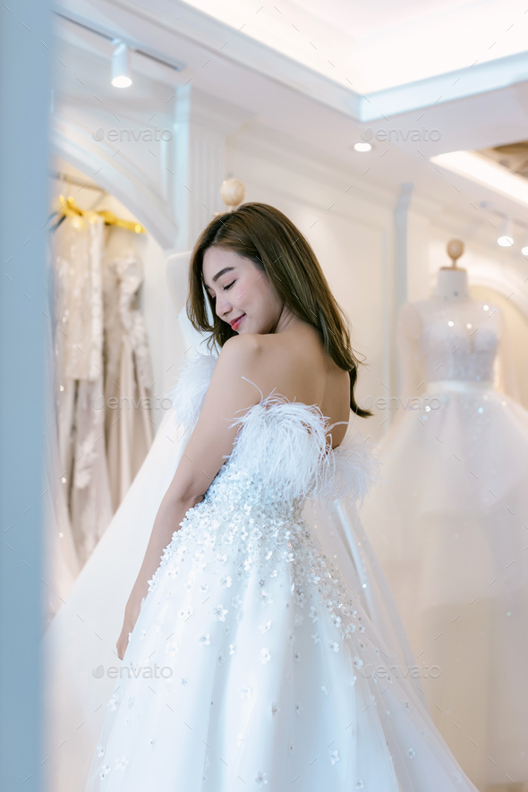 Bride and groom wear dress and try to fitting in modern wedding studio ...