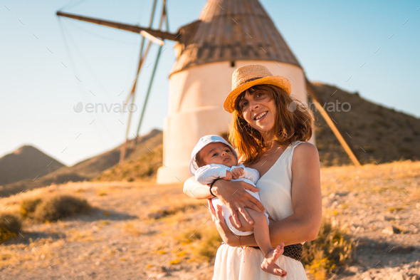 Mother visiting traditional windmills with a baby in arms Stock Photo ...