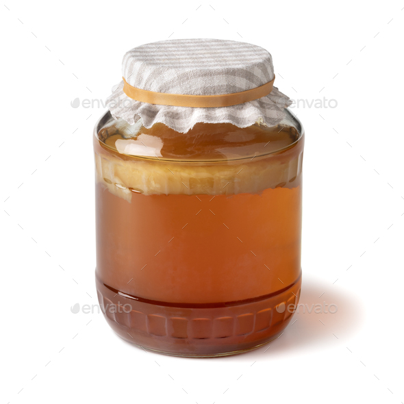 Glass jar with a Kombucha tea mushroom, scoby to produce Kombucha drink ...