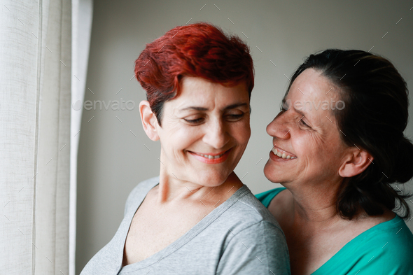 Senior Gay Lesbian Couple Hugging Each Other Inside Home Lgbtq Aged