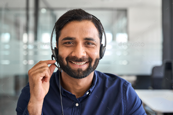 Smiling Indian man call center agent wearing headset in office ...