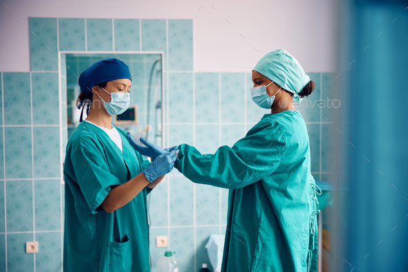 Black female surgeon and nurse getting ready for operating room in the ...
