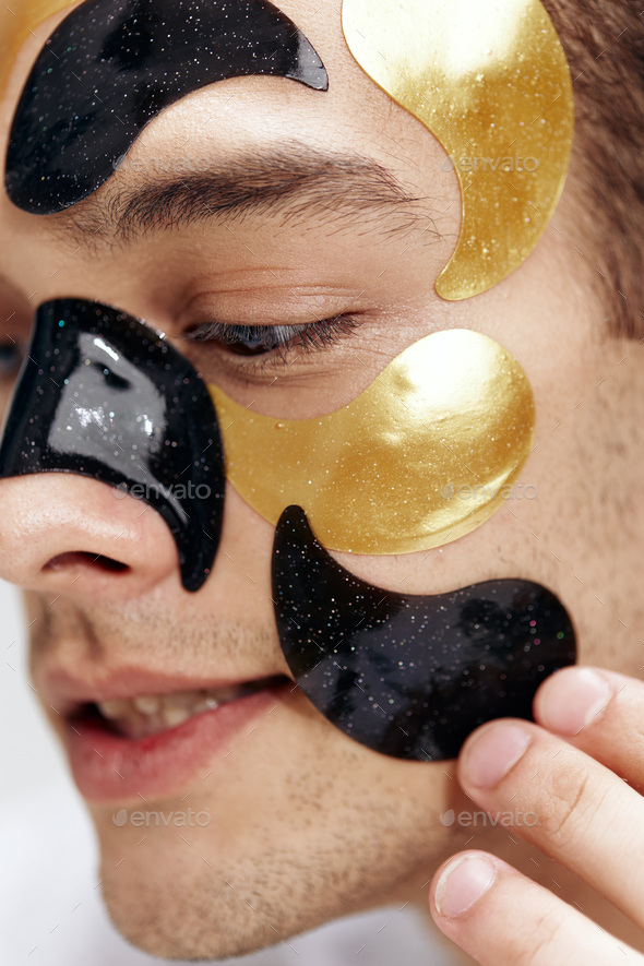 handsome guy many patches on the face touches face with hands light ...