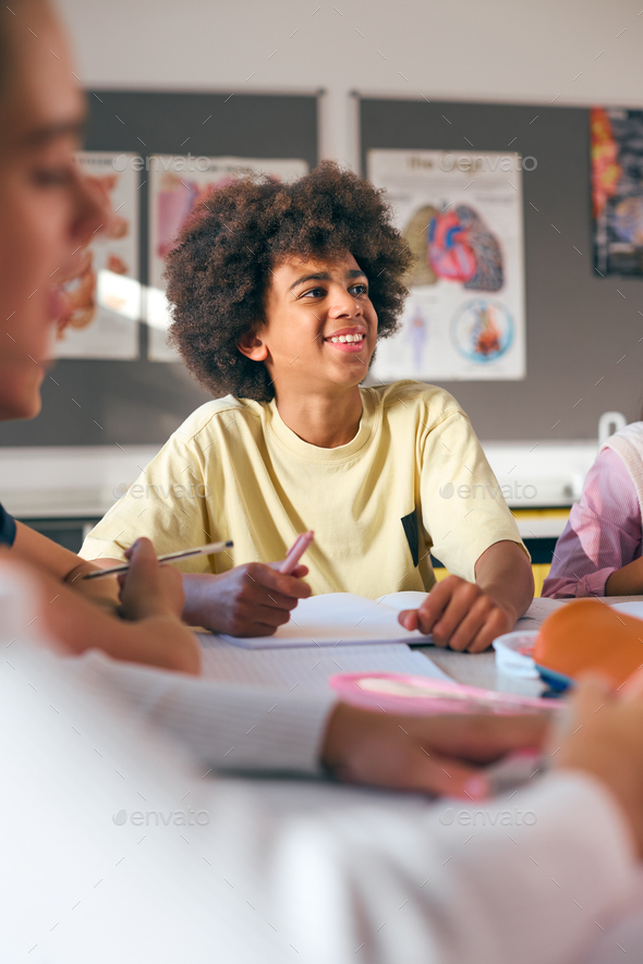 Secondary Or High School Students Sitting Around Table In Science Class ...