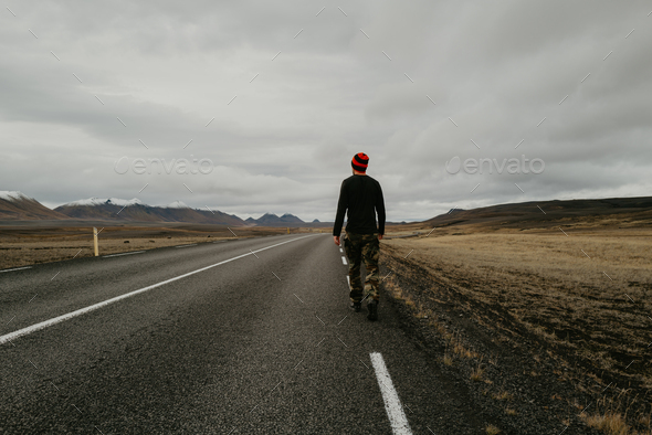 View from behind man walking on the road in Iceland Stock Photo by ...